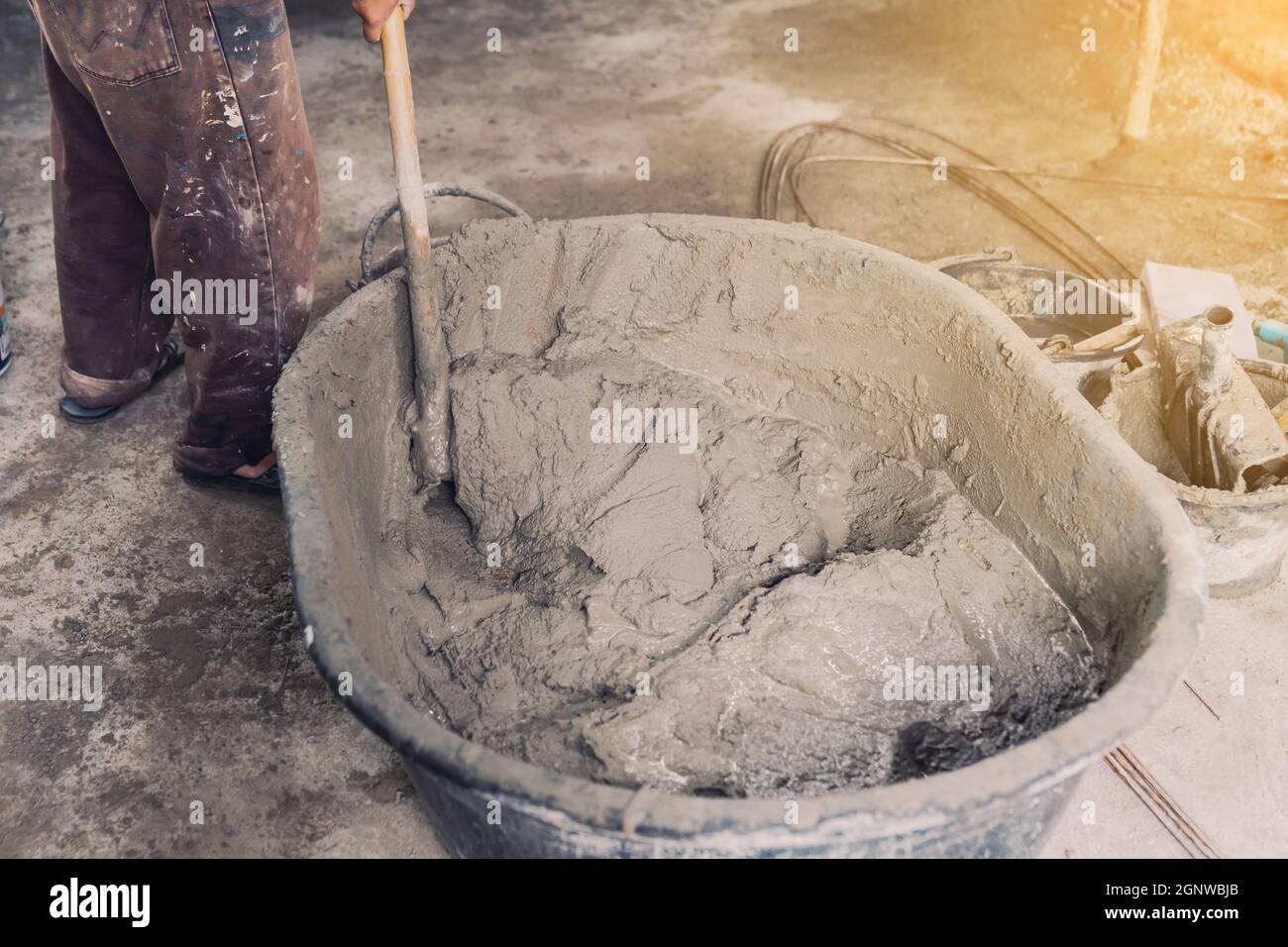 Worker man house builder mix mortar from a trough in bucket Stock Photo ...