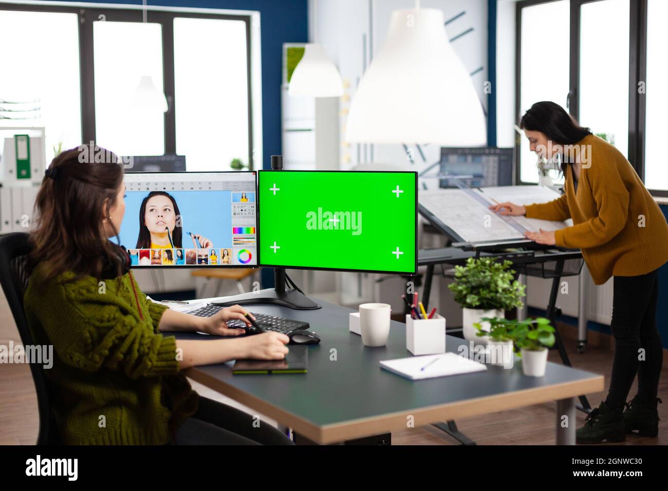 Woman digital artist working editing creative photo using greenscreen ...