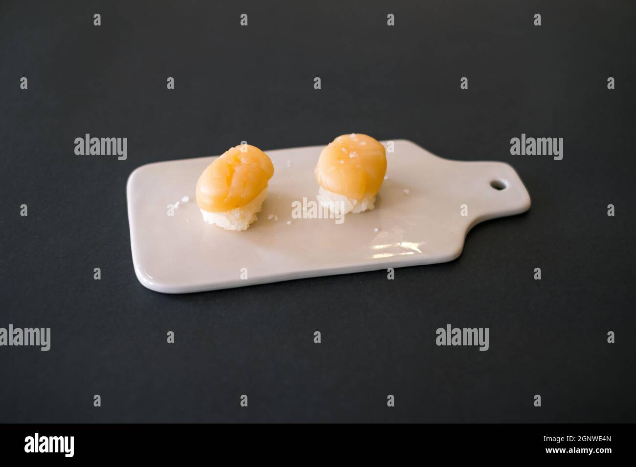 Two Nigiri Sushi with scallop served on beige board. Two sushi pieces ...
