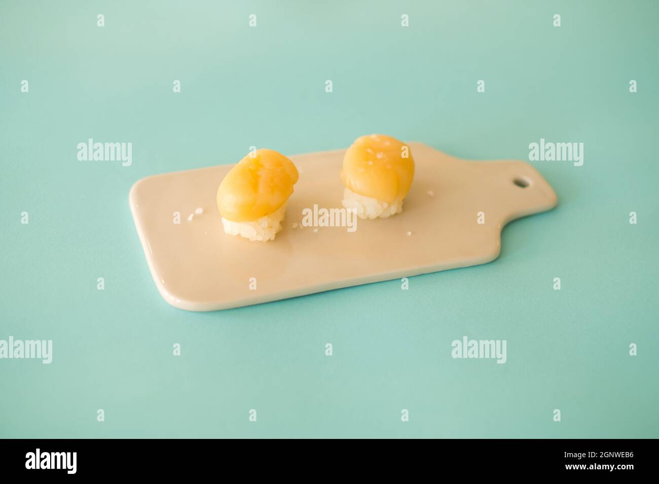 Two Nigiri Sushi with scallop served on beige board. Two sushi pieces ...