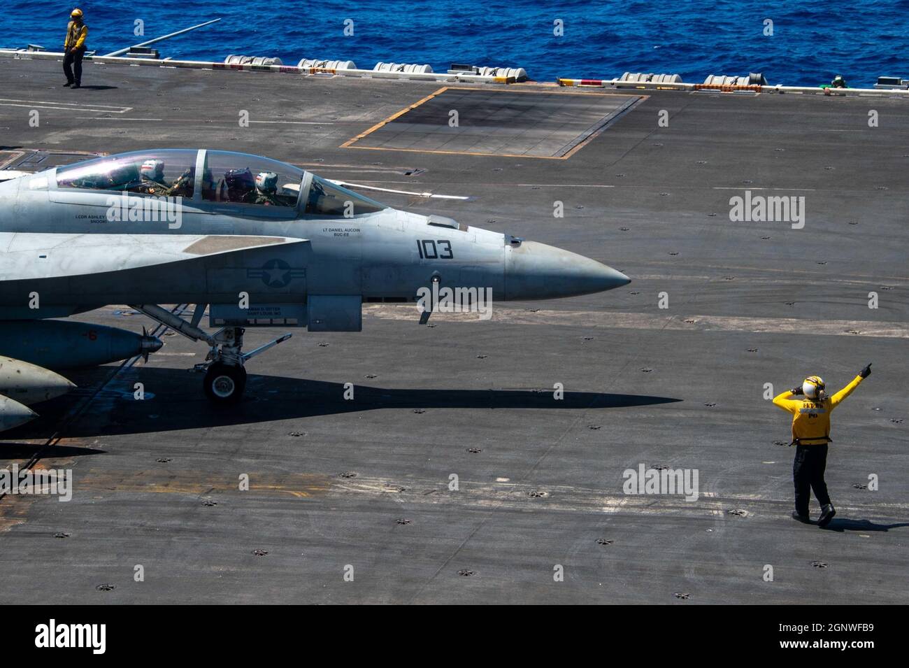 210927-N-RO680-1396 PHILIPPINE SEA (Sept. 27, 2021) A Sailor directs an F/A-18F Super Hornet ...