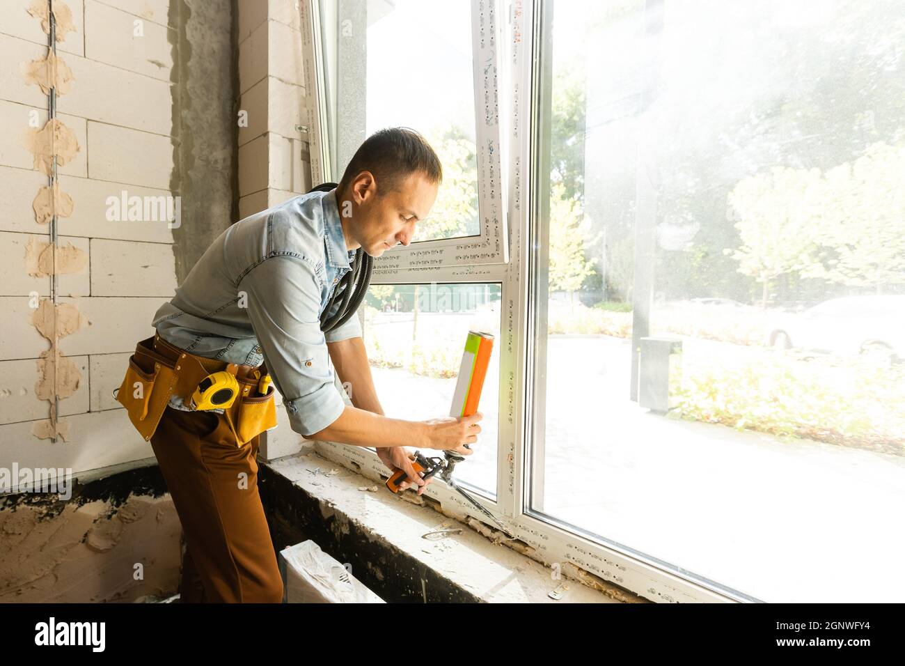 Construction worker installing window in house Stock Photo - Alamy
