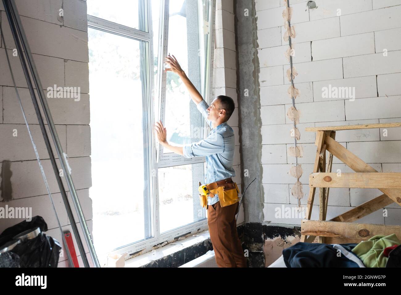 Construction worker installing window in house Stock Photo - Alamy