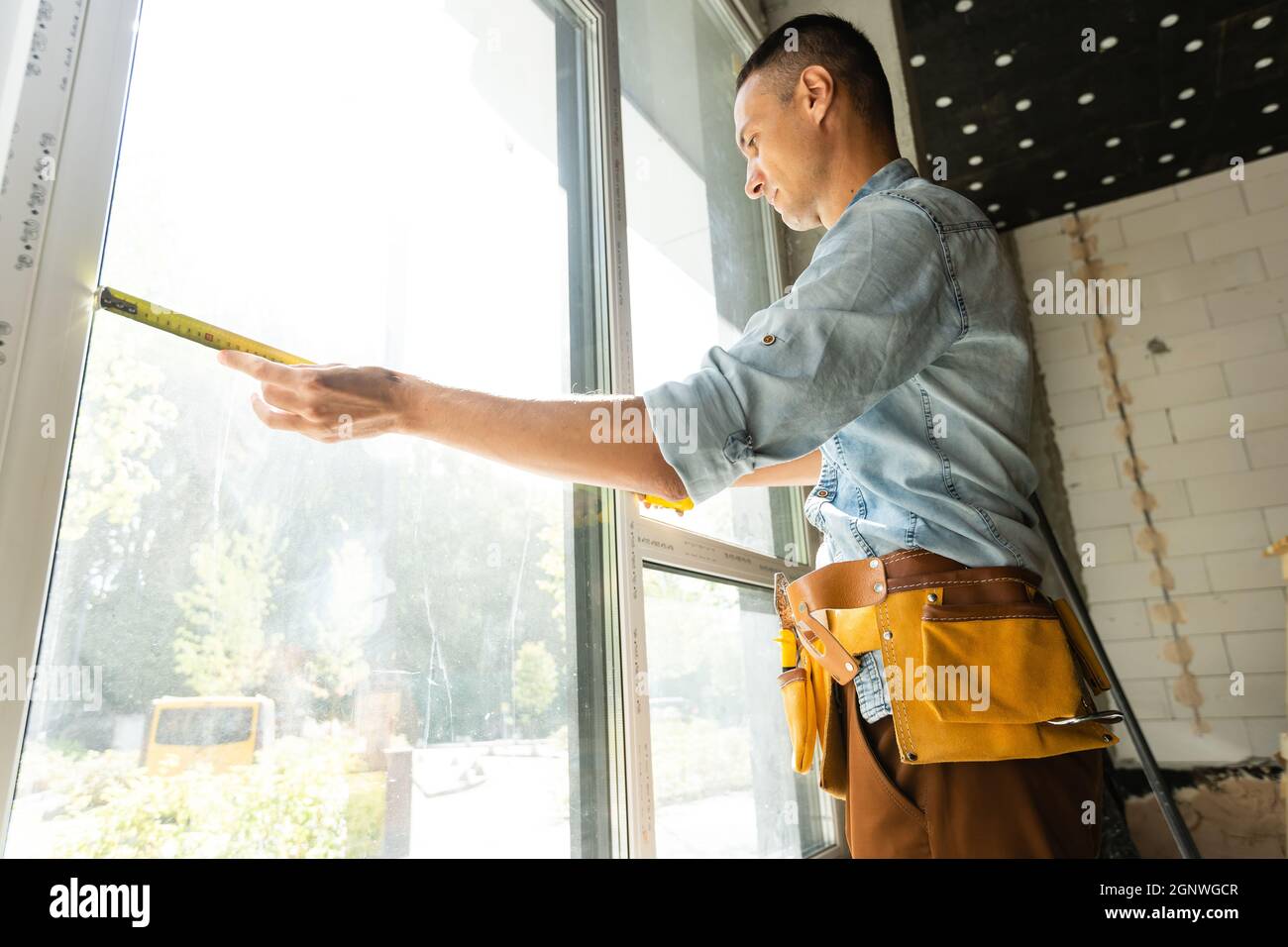 Construction worker installing window in house Stock Photo - Alamy