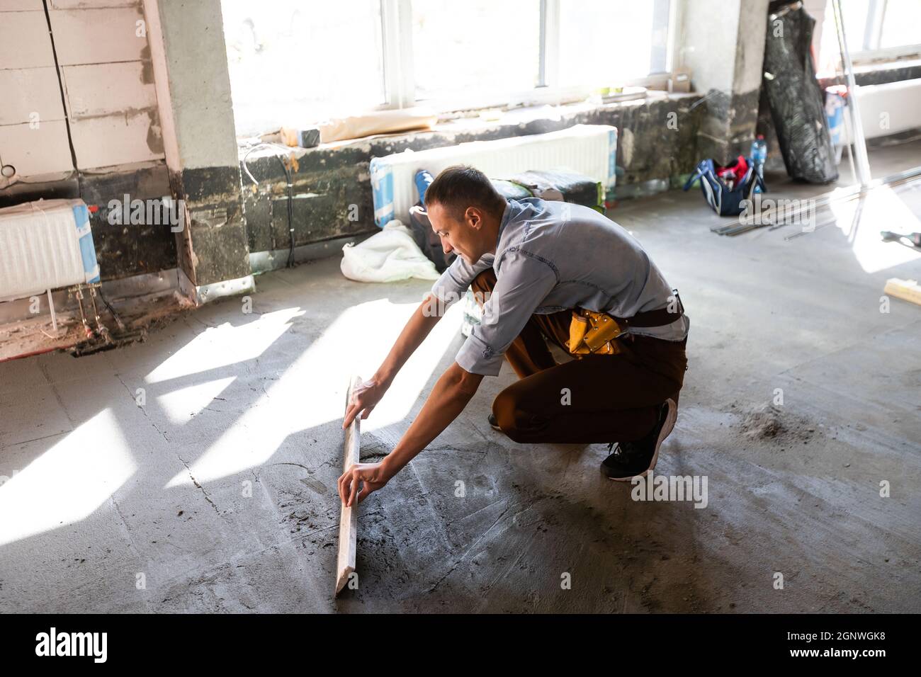 Workers are installing the floor. repairman grouting the floor Stock ...