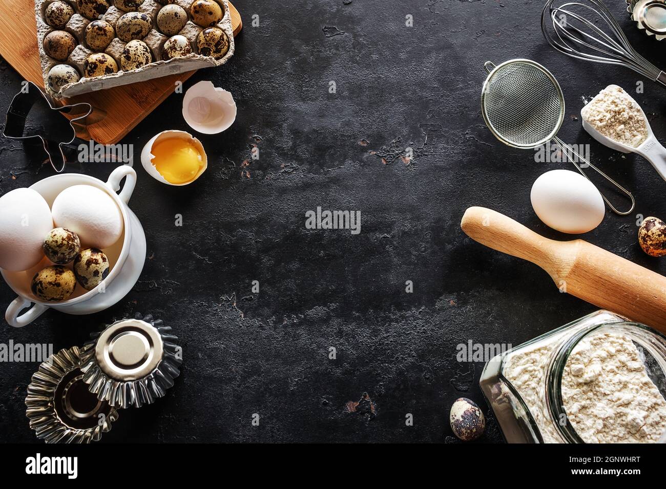 frame of products and utensils for baking on a black background with ...