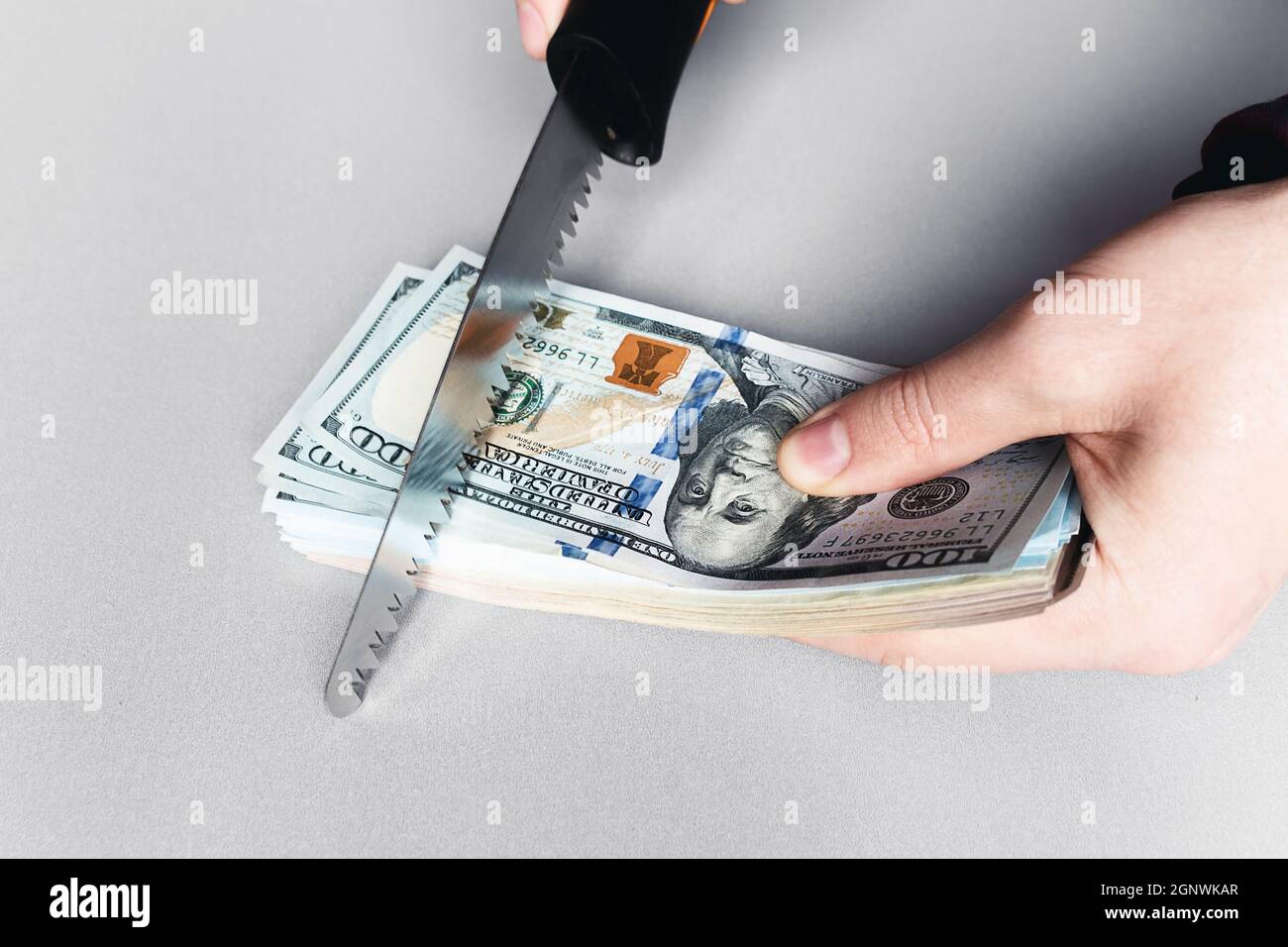 sawing money with a saw on a white background concept corruption Stock ...