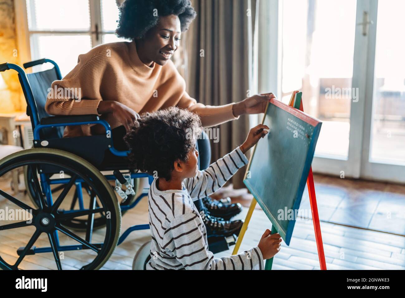 Happy child doing math exercises with her mother ot teacher together ...
