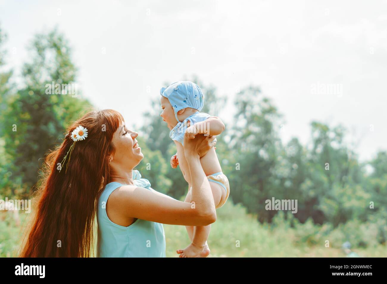 mother raises the child in her arms Stock Photo - Alamy