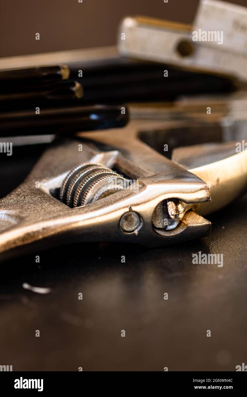 Adjustable spanner, ruler and other instruments on black wooden table ...
