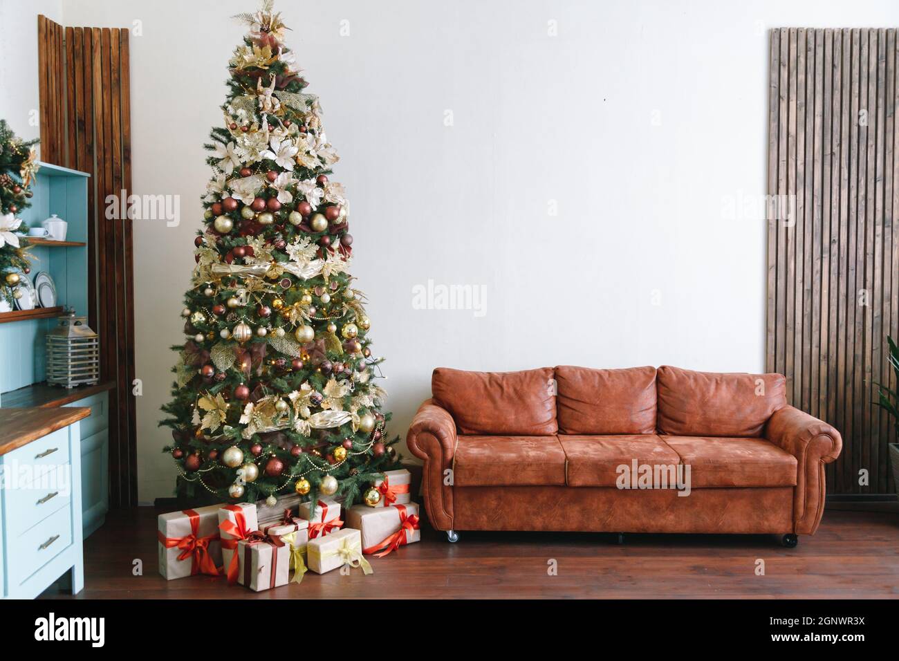 Christmas tree with leather sofa in a white room. Interior living room ...