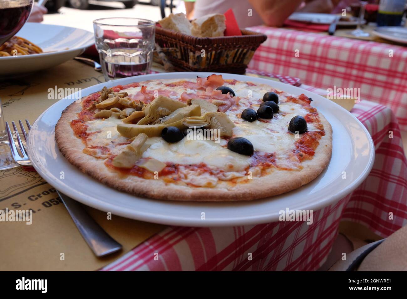 A classic quattro stagioni pizza served outside in a pizzaria ...