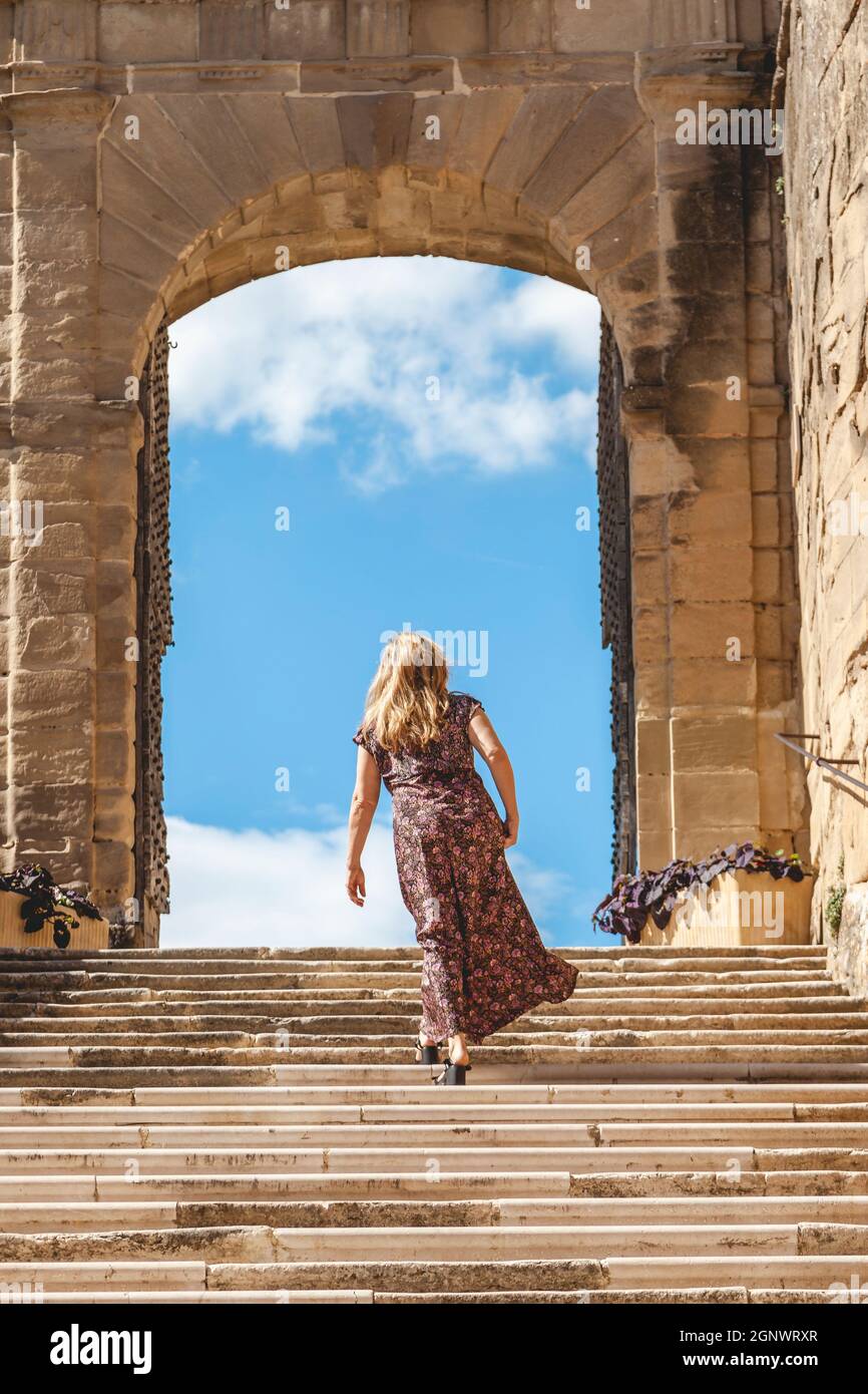 woman in a long dress is climbing the steps of the abbey of Saint ...