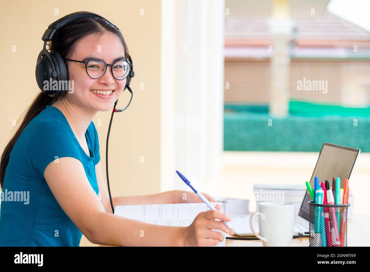 Young Asian teenage girl student with headset glasses is looking while ...