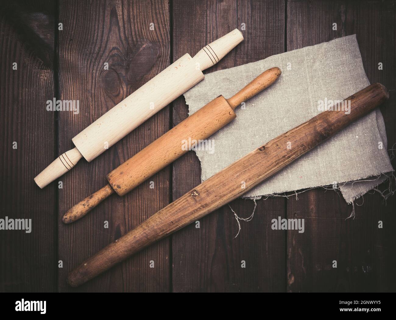 wooden rolling pins for rolling dough on a black background, new and ...