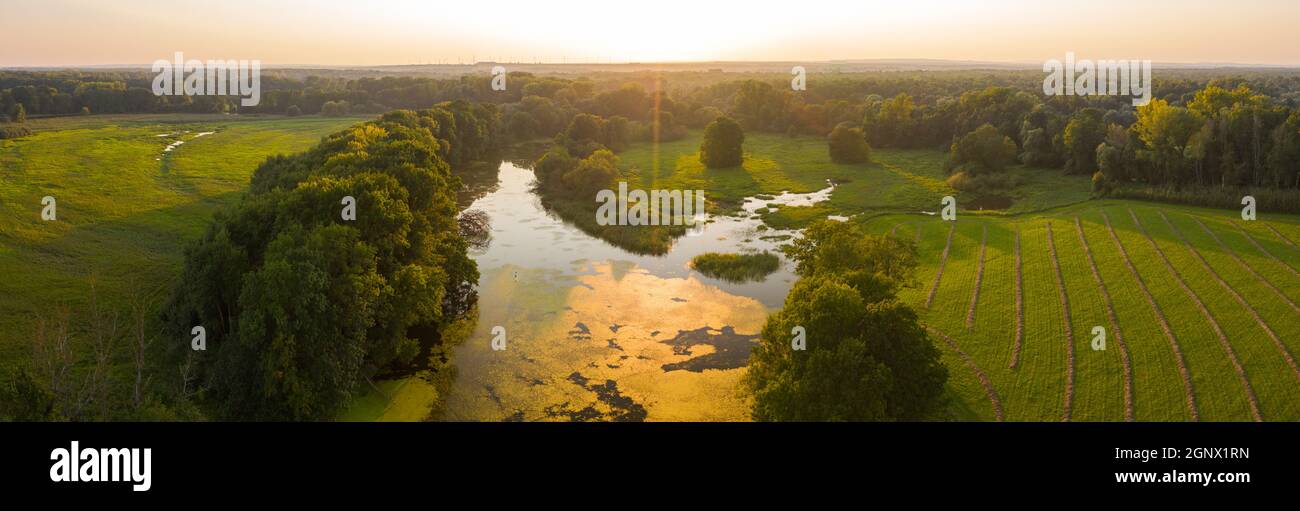Nature scenery from aerial perspective with river and mowed meadow at ...