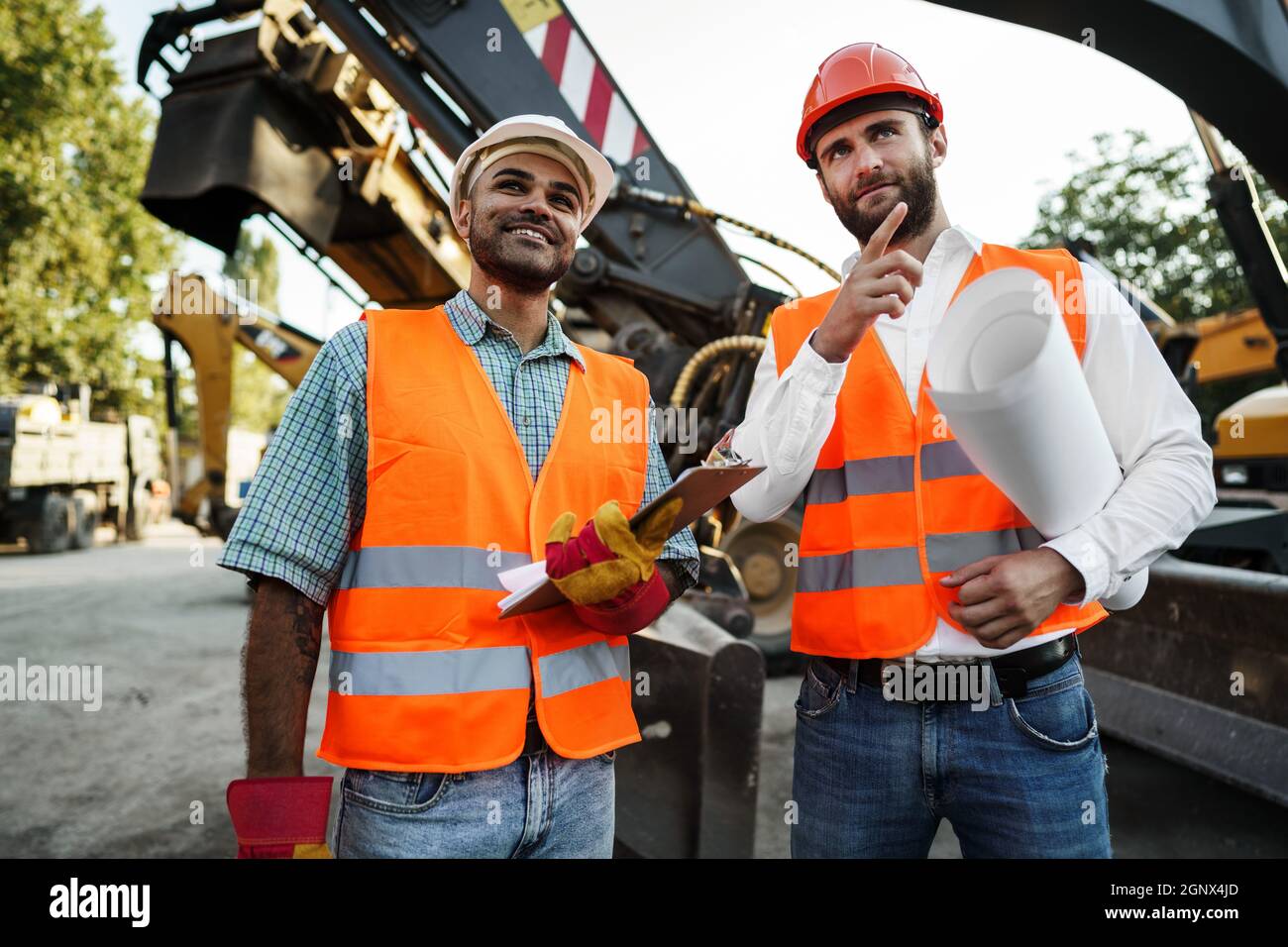 Two men engineers discussing their work standing against construction ...