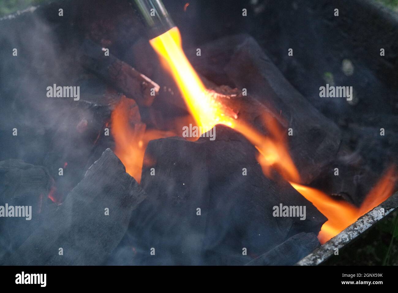 Fire on logs in fire pot with embers and burning coal. Bonfire with ...