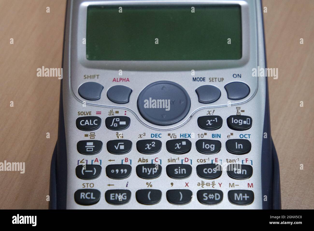 Calculator with colored keys or buttons isolated on a wooden background ...