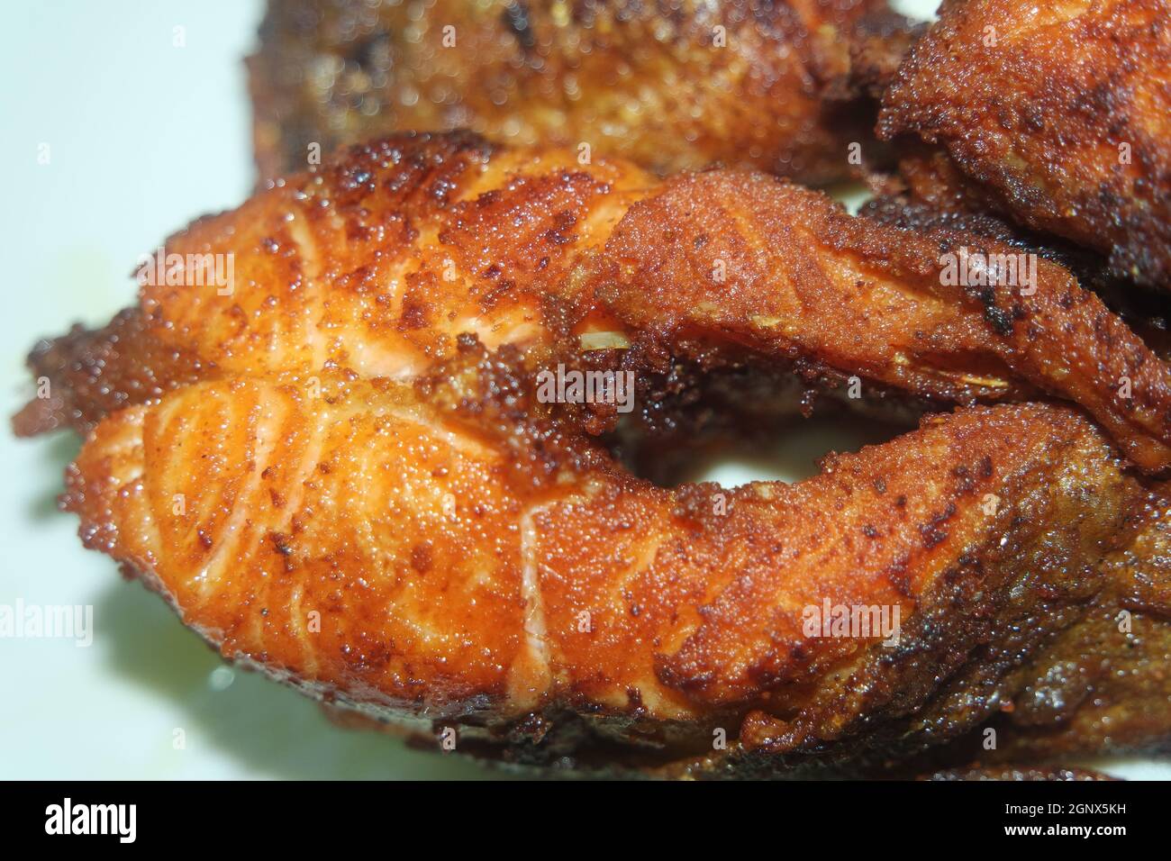 Spicy and crunchy barbecue of fried fish fillet on a white background ...