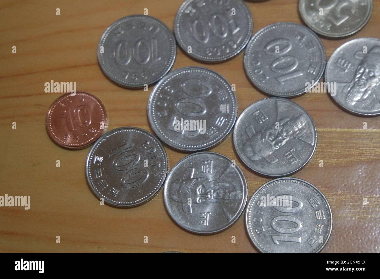 Silver shining Korean won coin scattered over a wooden floor Stock ...