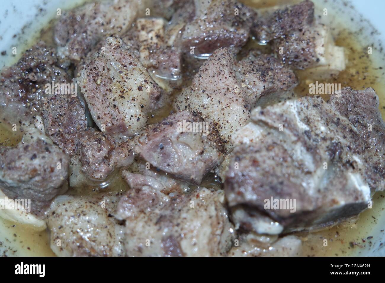 Top view of siri paaye or paya dish garnished with diced ginger, long ...