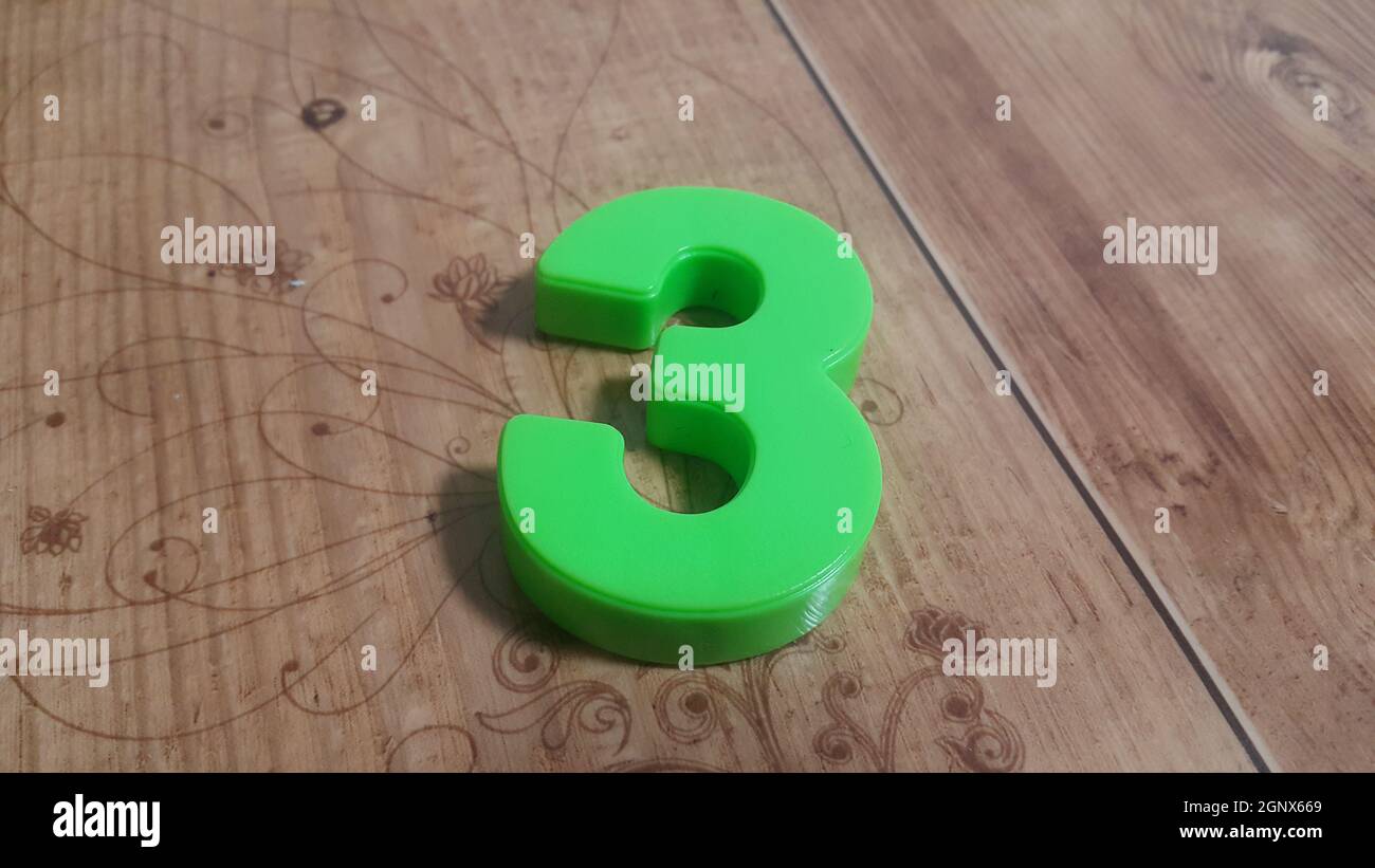 Plastic colored alphabets making words are placed on a wooden floor ...