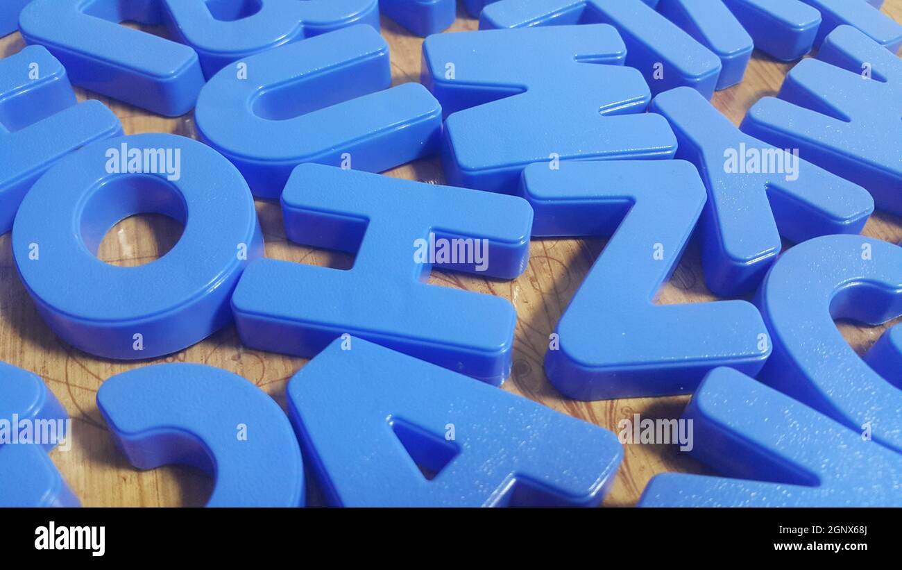 Set of plastic alphabet letters placed on a wooden floor. Alphabet set ...