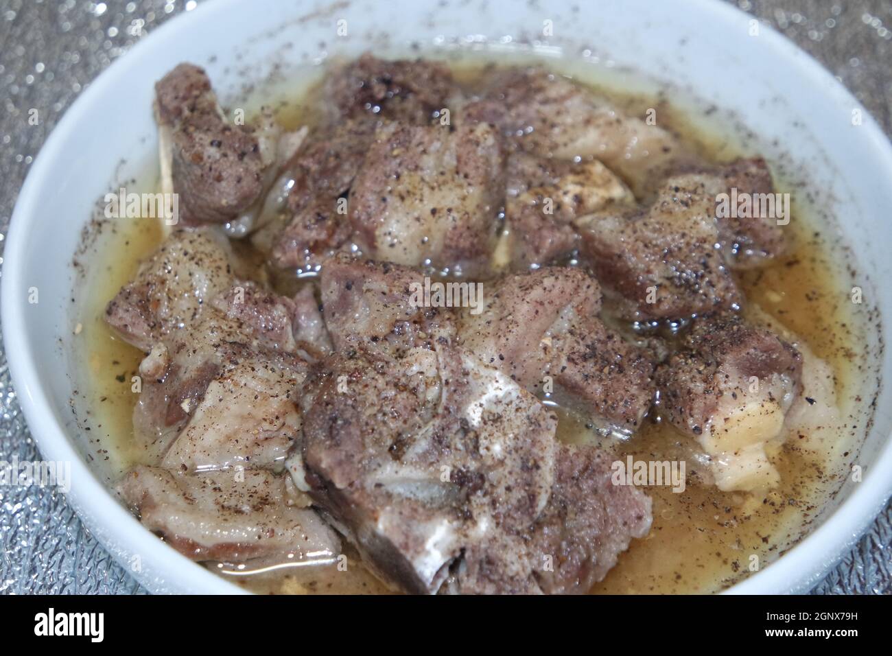 Top view of siri paaye or paya dish garnished with diced ginger, long ...