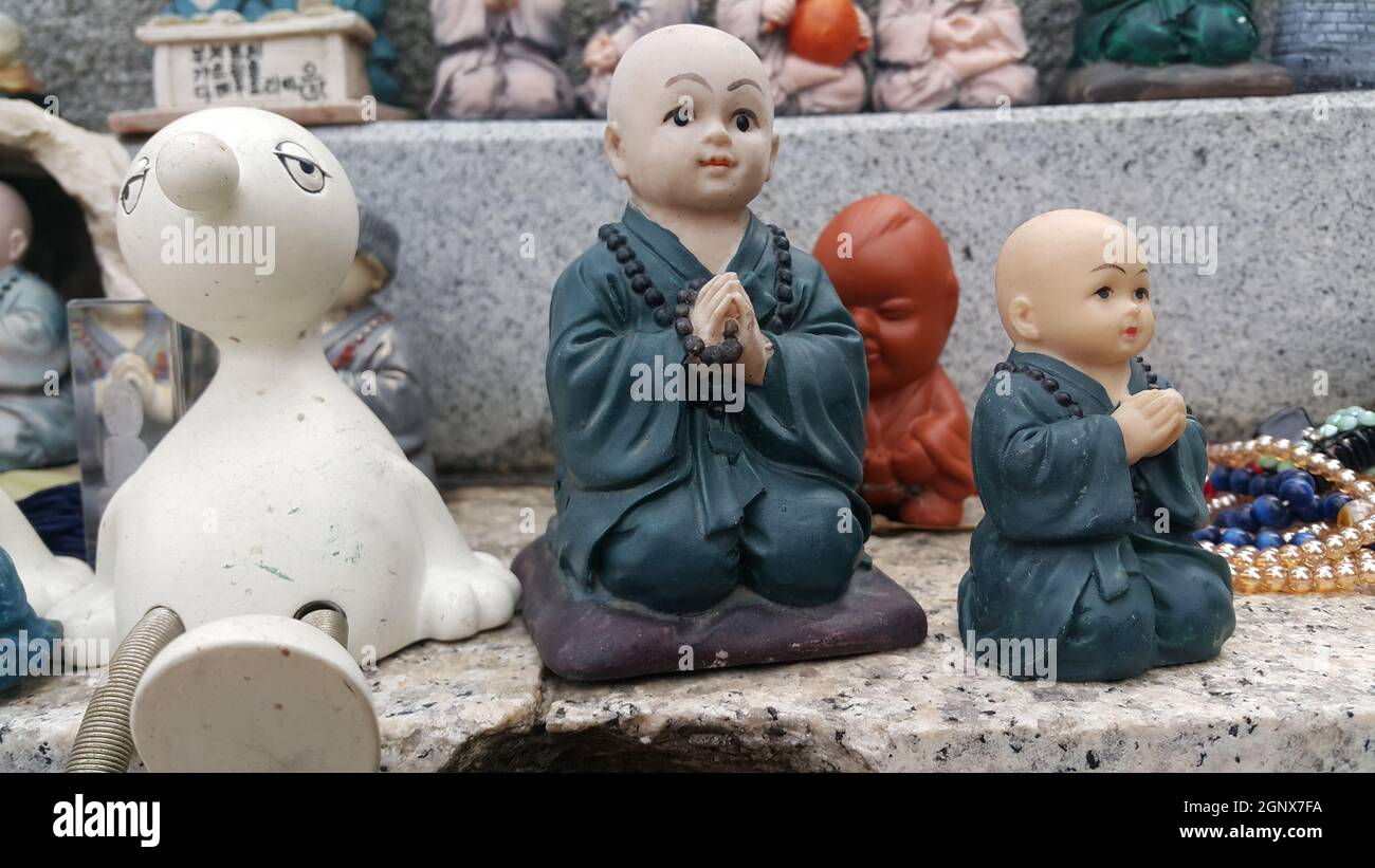 Closeup view of statues of religious monks. Buddha mini statue with ...