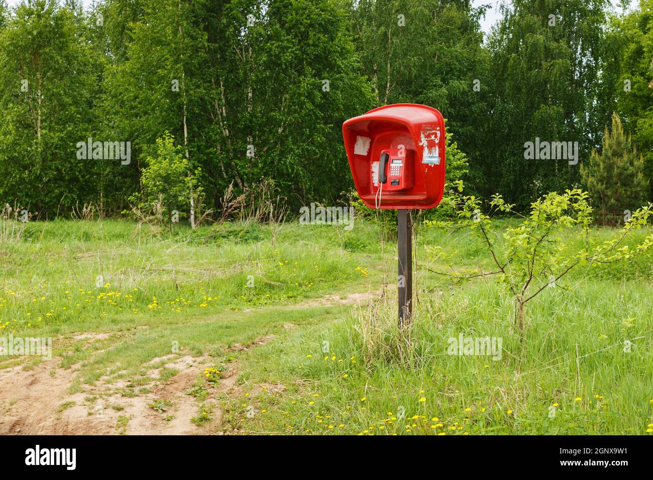 red payphone. Payphone standing in the field. Village telephone. Russia ...
