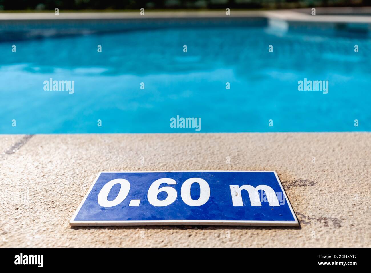 blue plastic plate at the edge of a swimming pool indicating a depth of ...