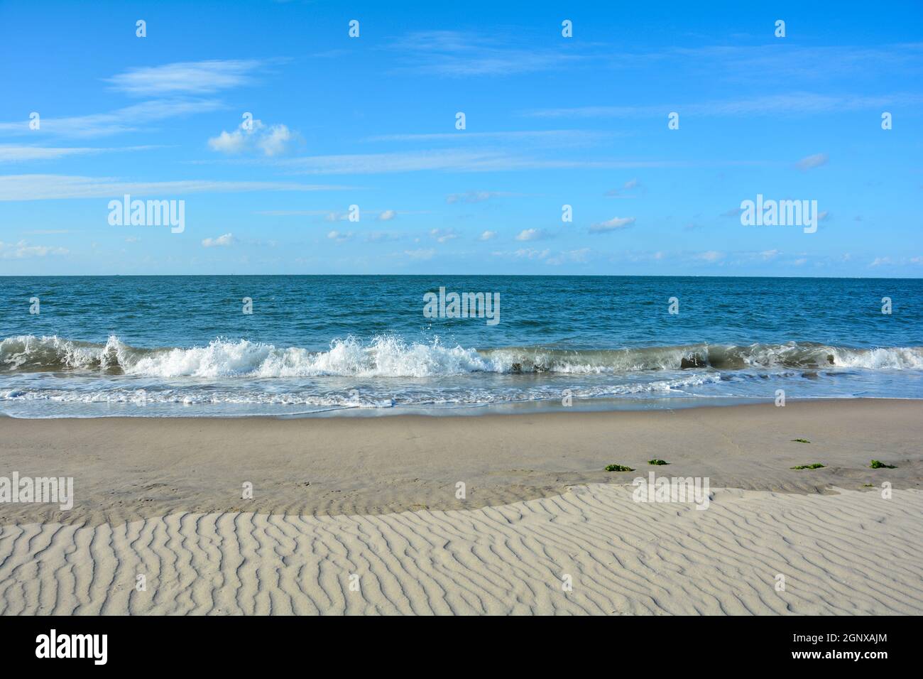 Waves on sand beach with blue sky with copy space Stock Photo - Alamy
