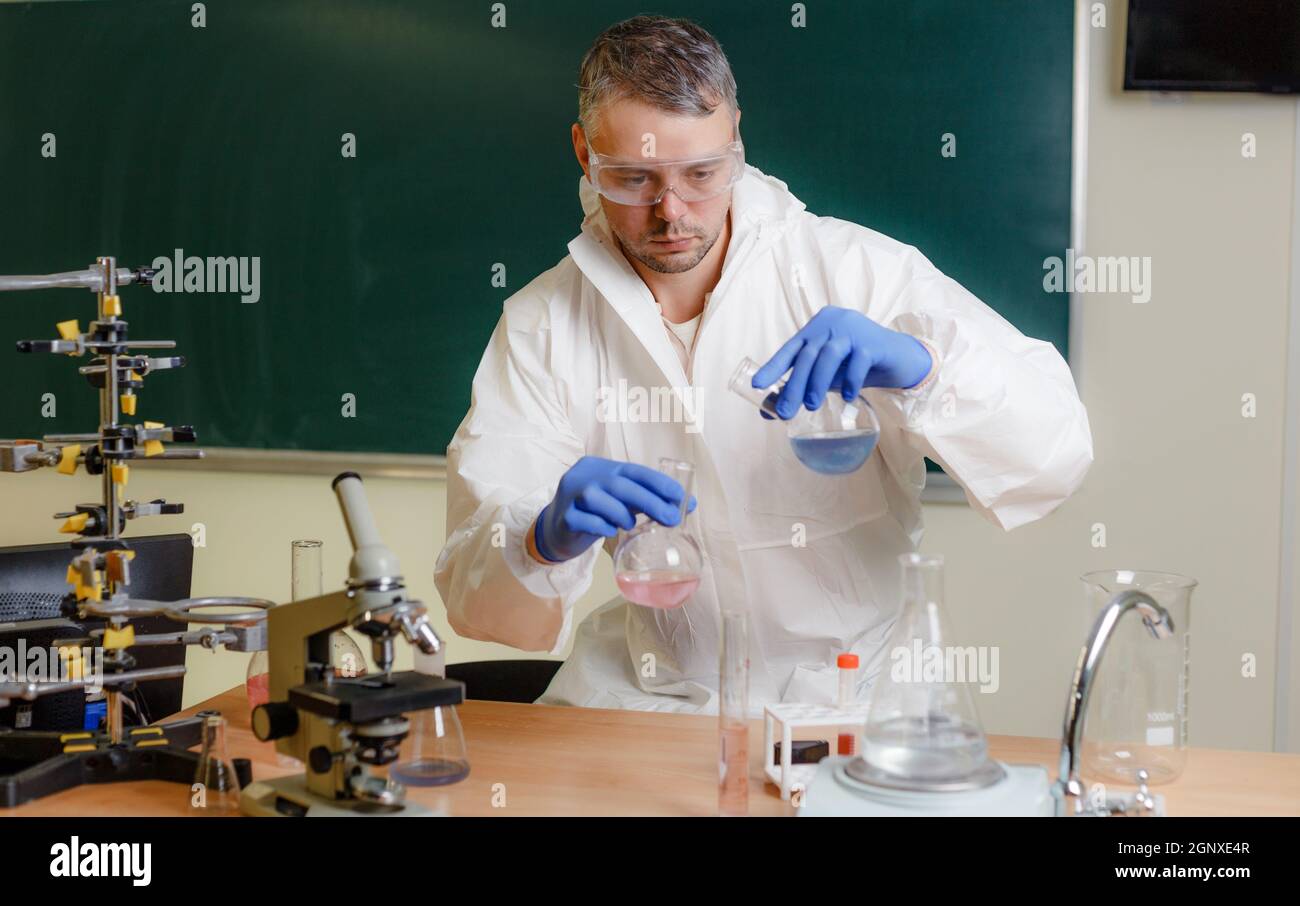 A male scientist in the lab is conducting research mixing various ...