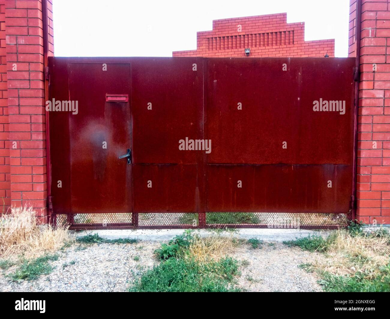 Steel rusty gates and a red brick fence Stock Photo - Alamy