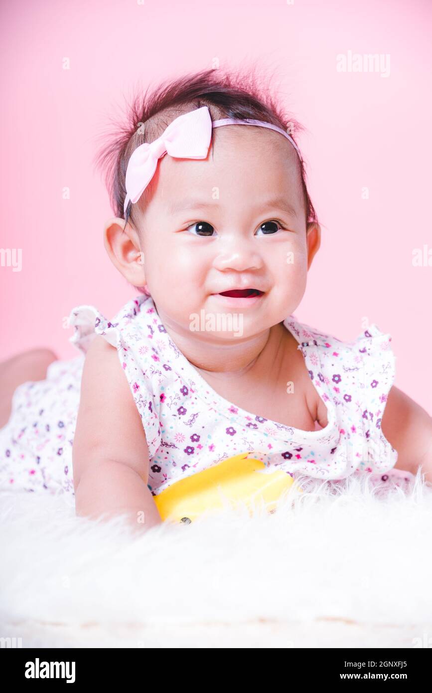 Asian girl cute baby smiling face on pink background Stock Photo - Alamy