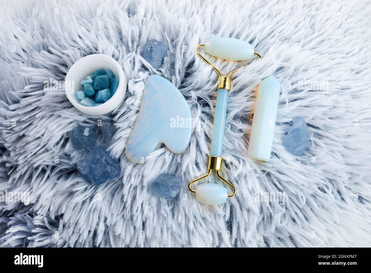 opal crystal facial roller and massage tool jade Gua sha on grey ...