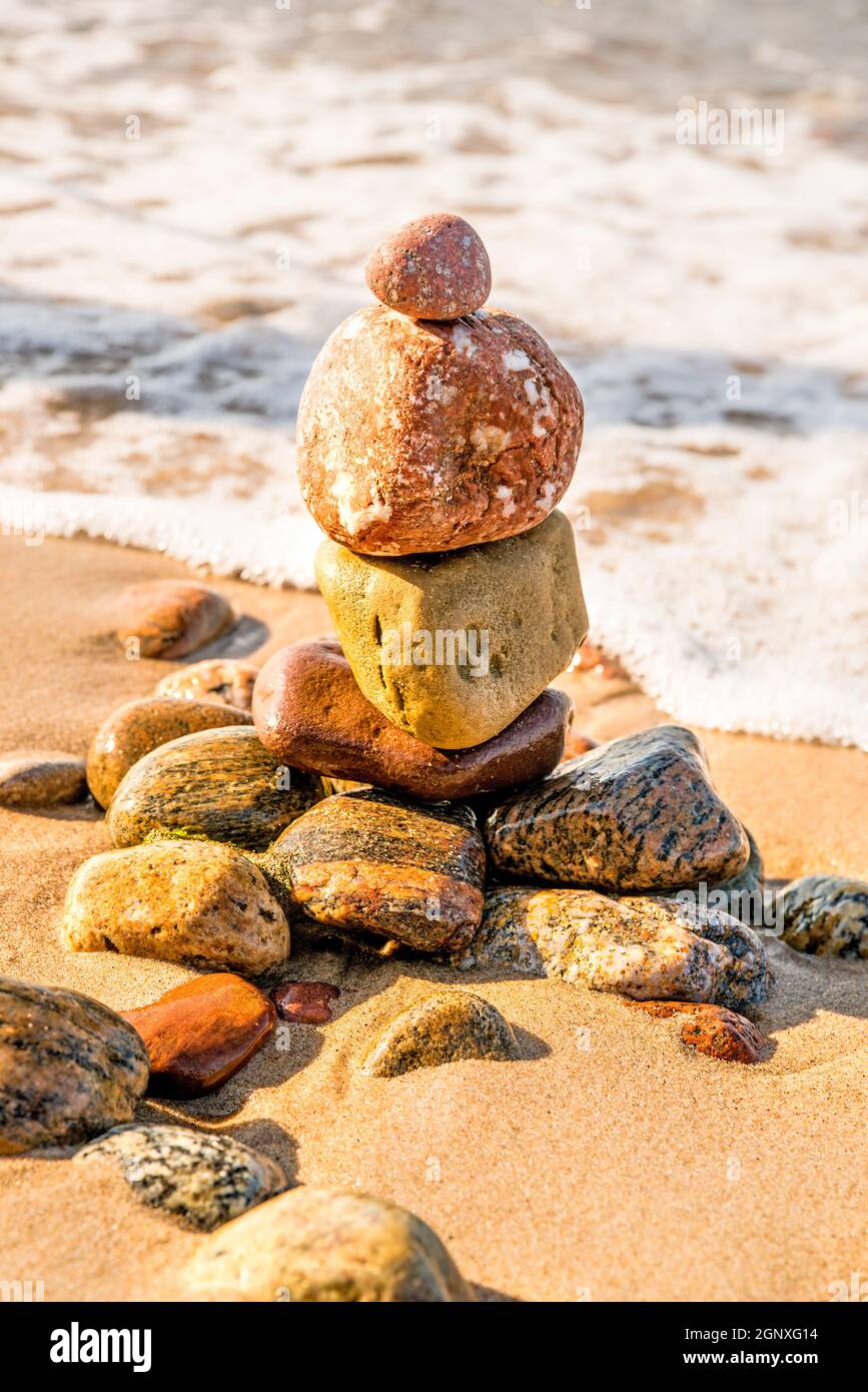 Zen stone pyramid at a beach with surf Stock Photo - Alamy
