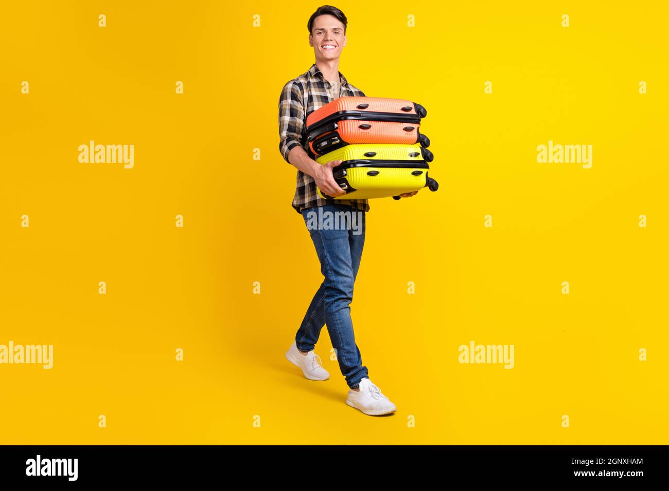 Photo of nice guy carry stack suitcase walk wear checkered shirt jeans ...