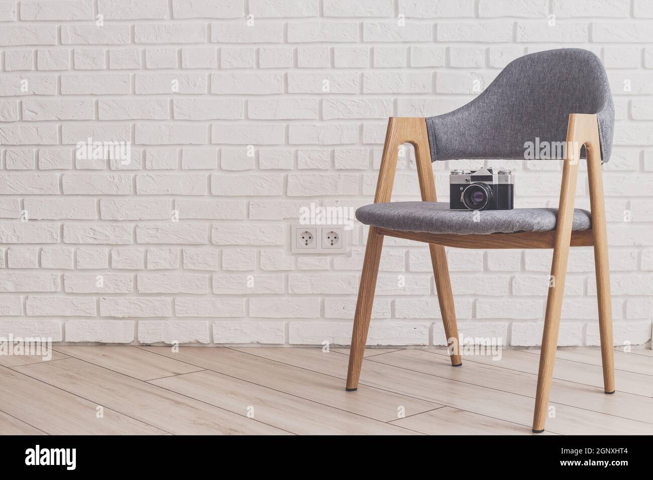Modern grey chair with white brick walls on background and wood floor ...