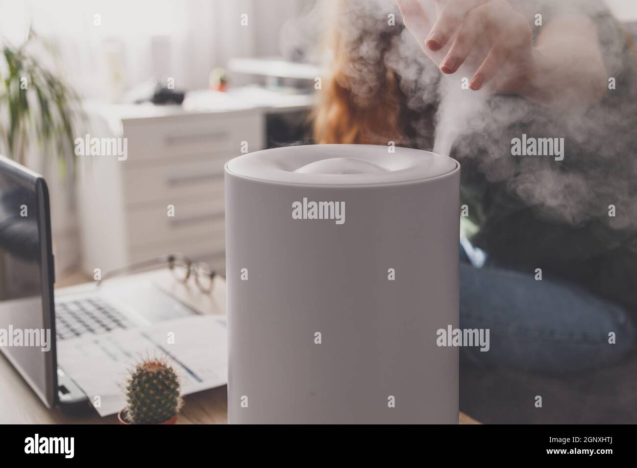 Woman freelancer uses a household humidifier in the workplace to ...