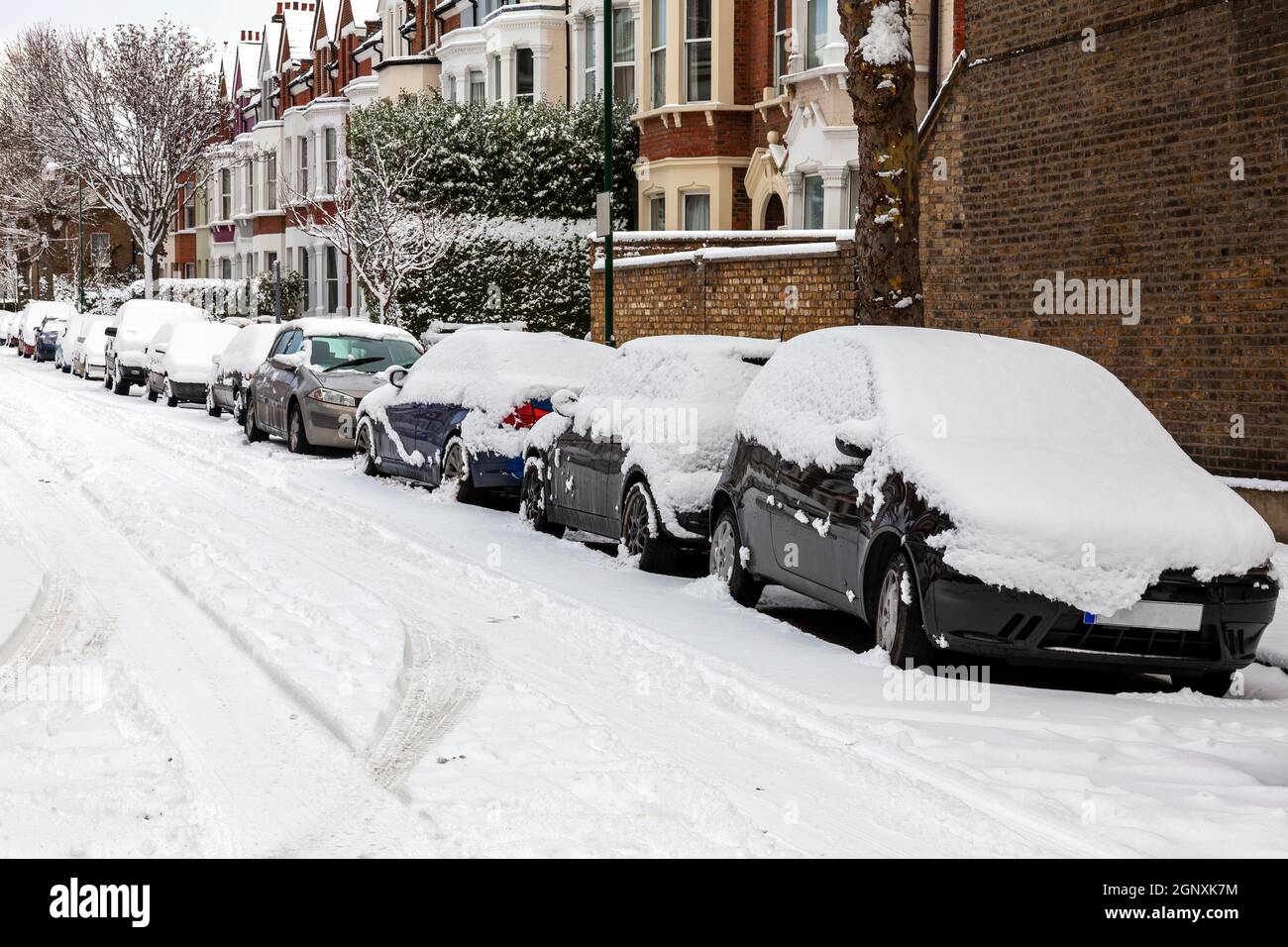 Street winter cityscape with snow terraced houses and frozen cars after ...