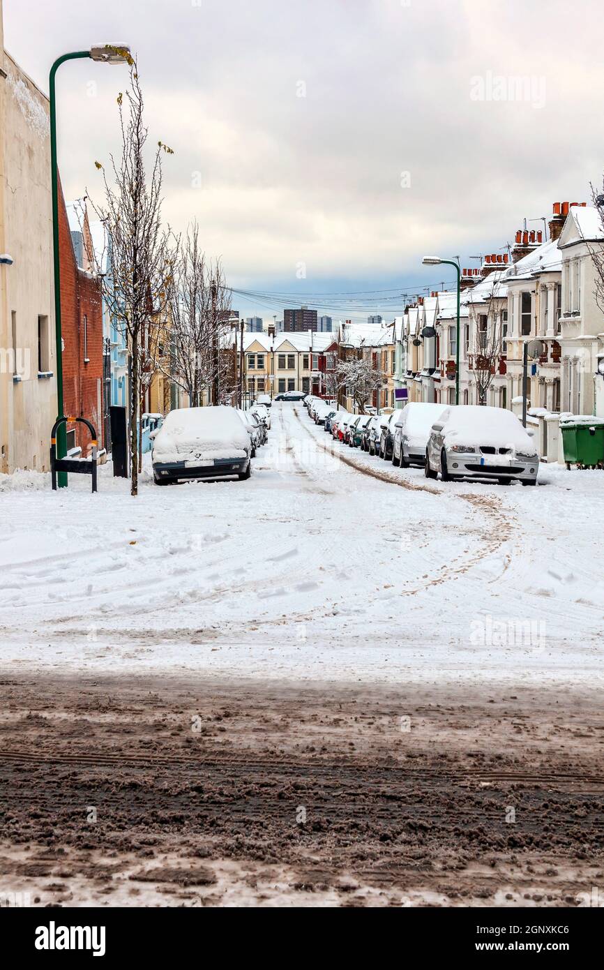 Street winter cityscape with snow terraced houses and frozen cars after ...