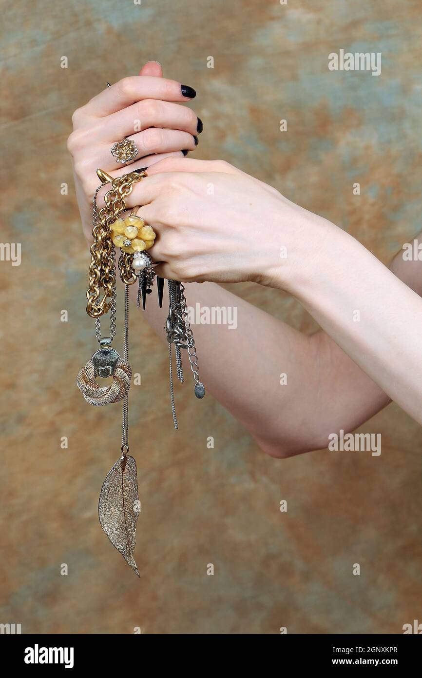 Female hands holding pile of expensive gold jewelry with rings and ...