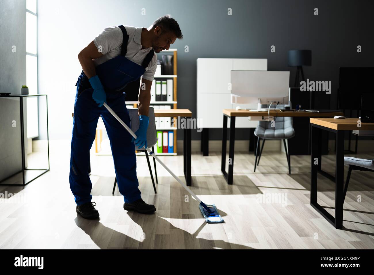 Male Janitor Mopping Floor In Face Mask In Office Stock Photo - Alamy