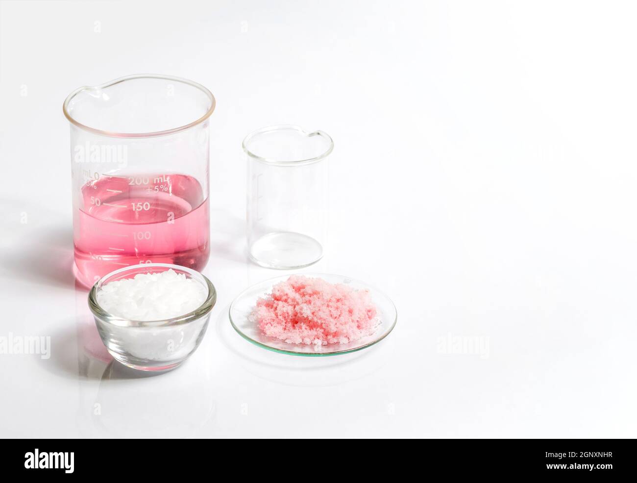 Chemicals for beauty care on white laboratory table. Pink flake ...