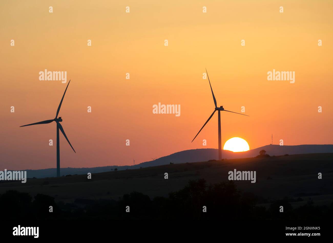 wind turbine and sun on sunset, renewable energy Stock Photo - Alamy