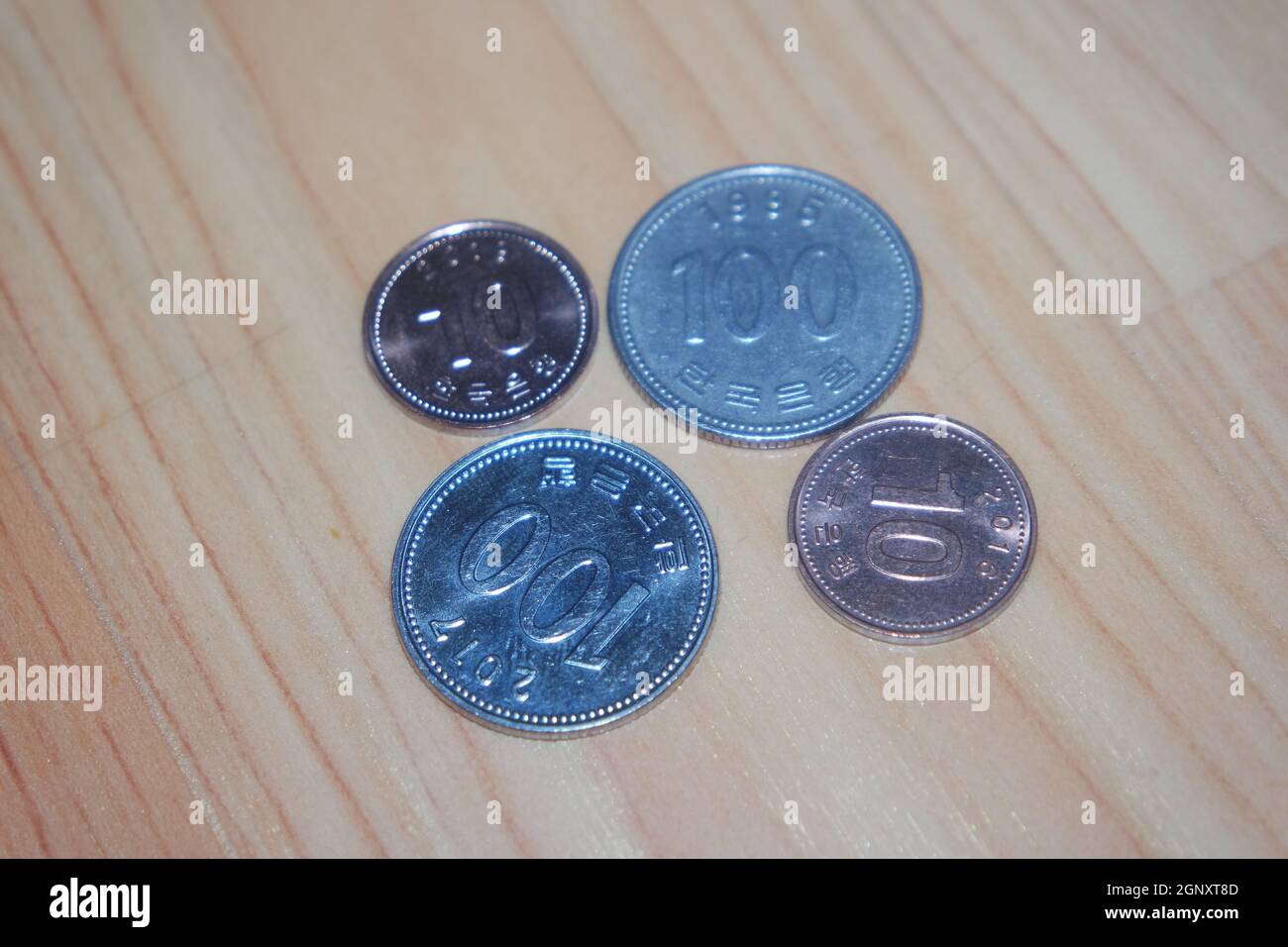 Silver shining Korean won coin scattered over a wooden floor Stock ...