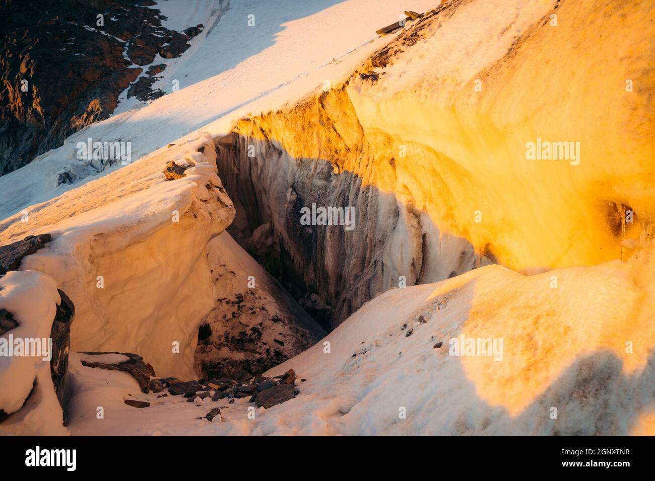 Giant crack in ice, destruction of a glacier in spring during sunset ...