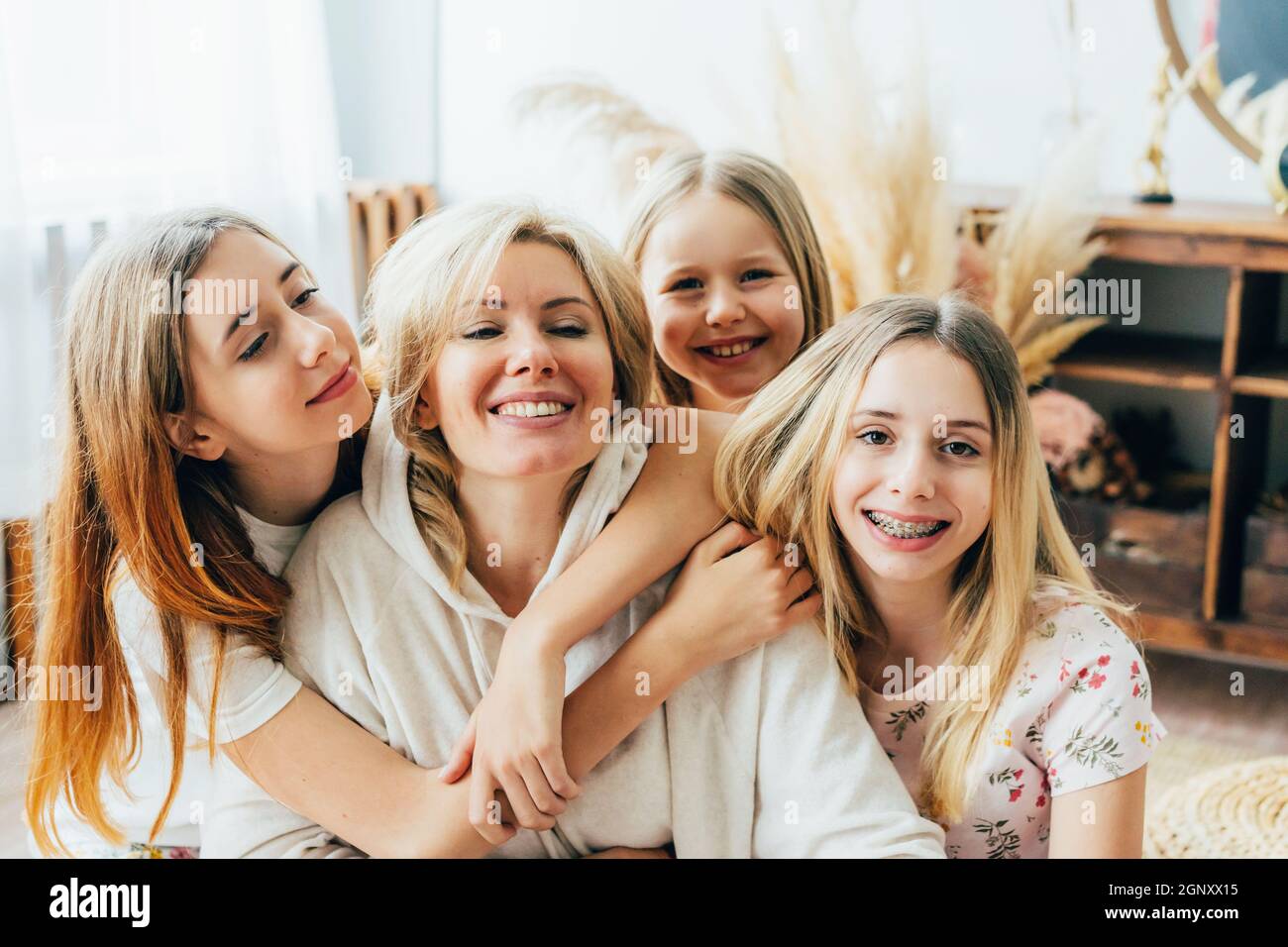 Happy carefree family, loving daughters hug mom. Cuddling and having ...